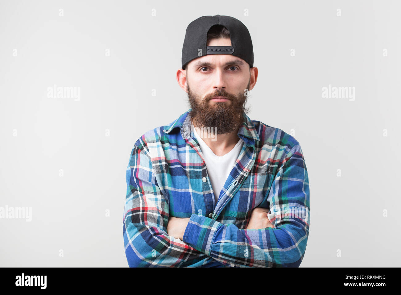 Hipster, lifestyle and people concept - Angry bearded man in a cap ...