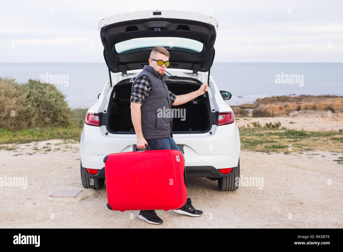 Man standing in back of car smiling and getting ready to go. Young ...