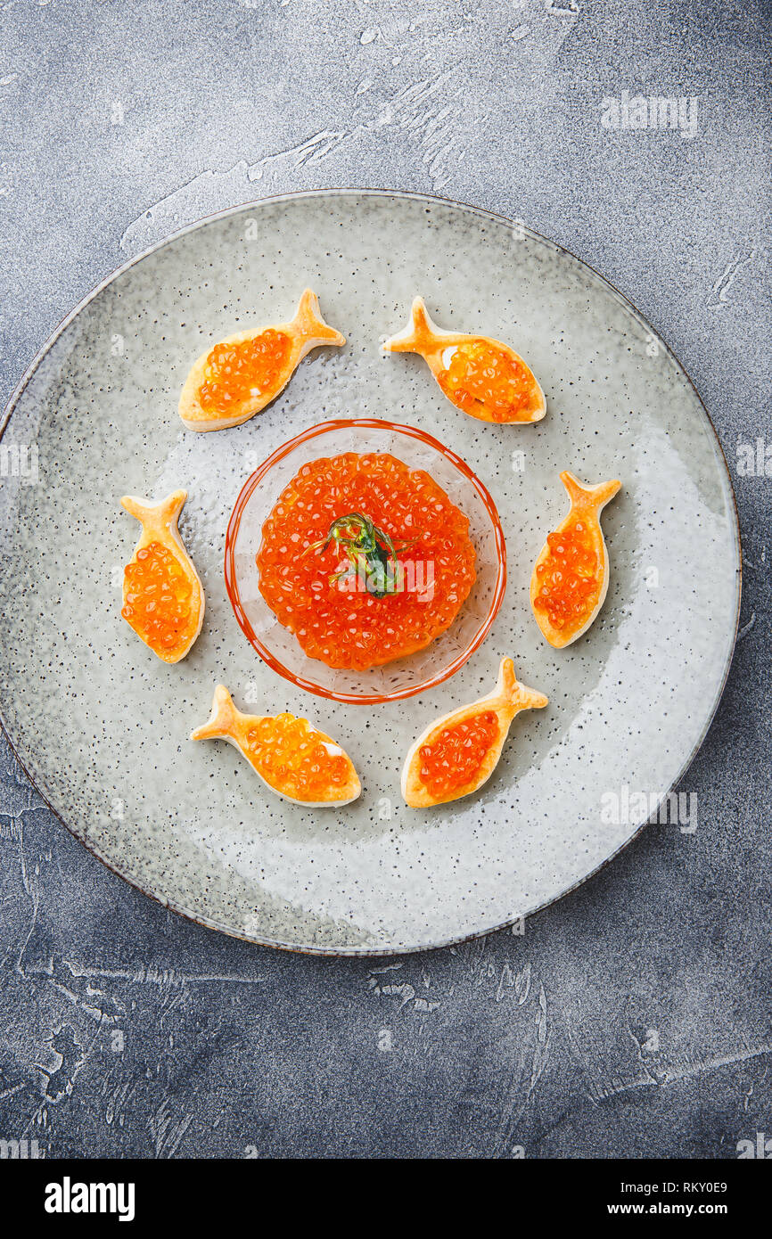 Delicious puff pastry tartlets in the shape of fish with red caviar on ...