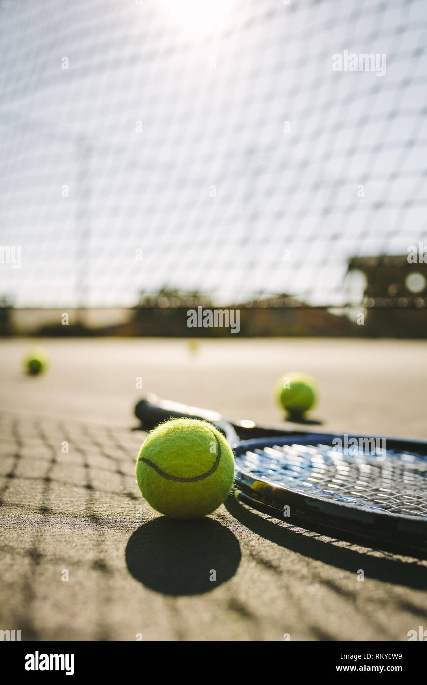 Ground level shot of a tennis racket with balls on tennis court. tennis ...