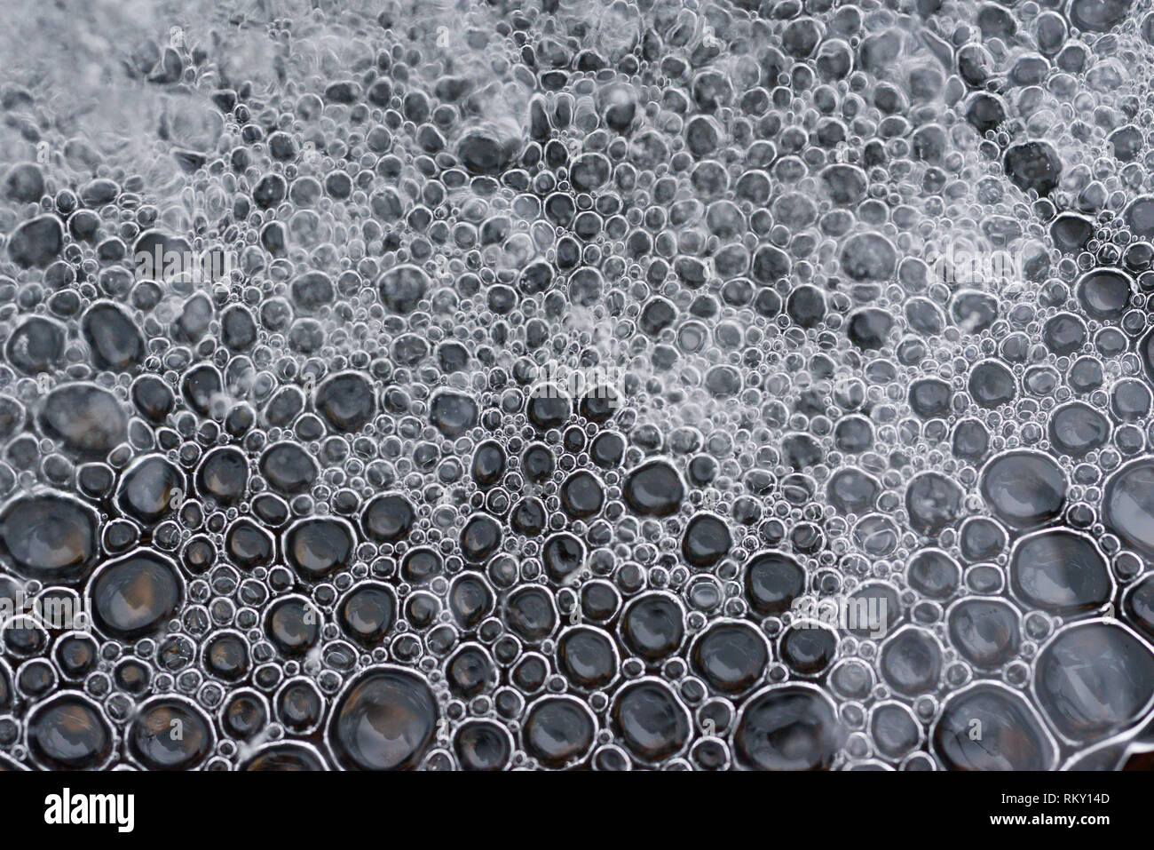 The accumulation of air bubbles under the thin crust of ice. Close up ...