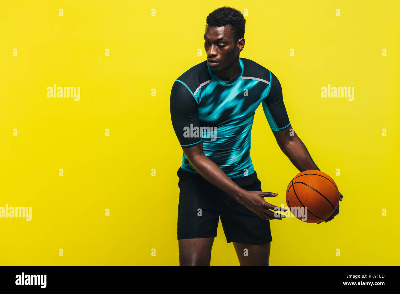 African man playing basketball on yellow background. Sportsman ...