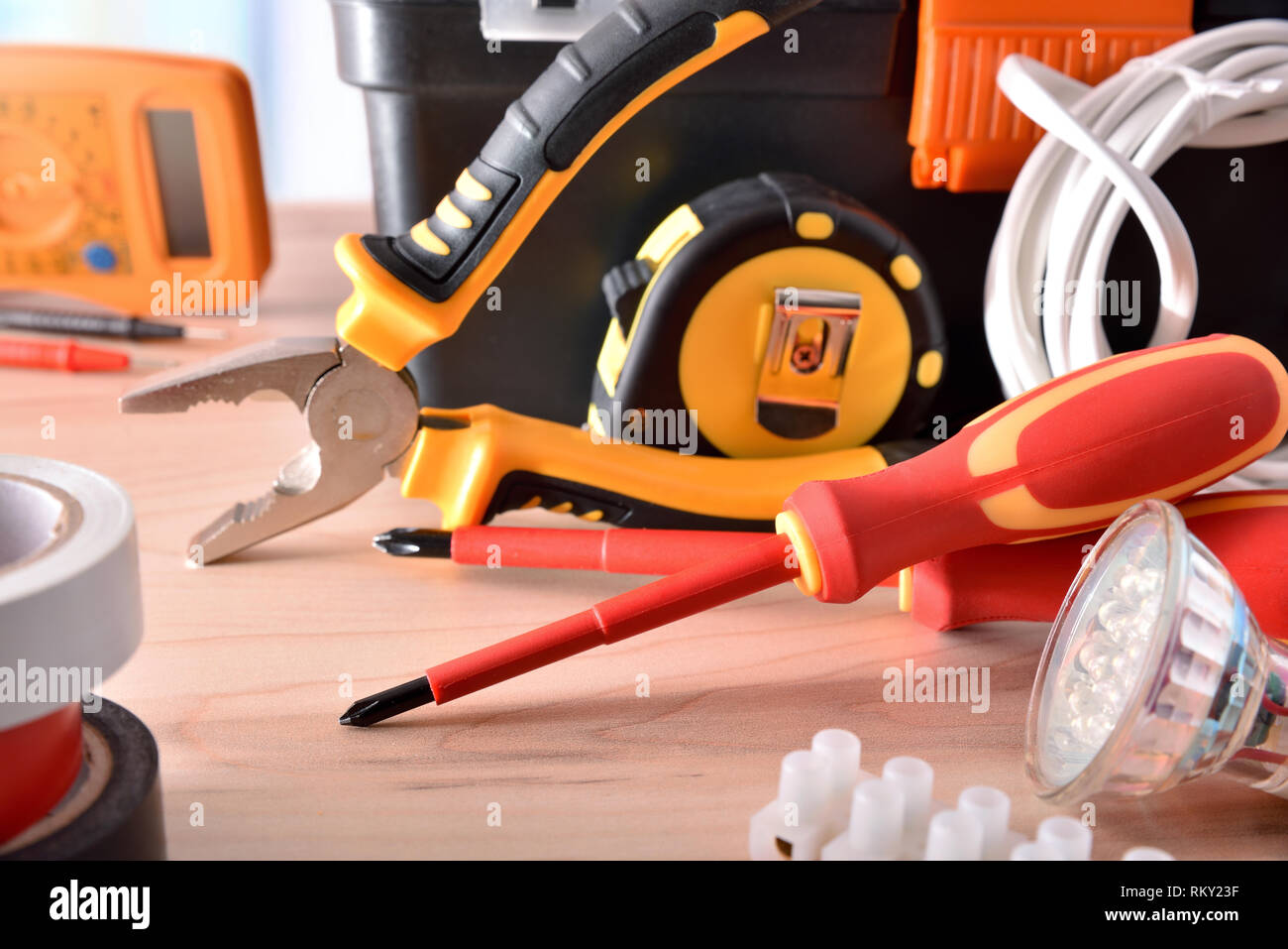 Variety of electricity tools on a wooden table with blue background ...