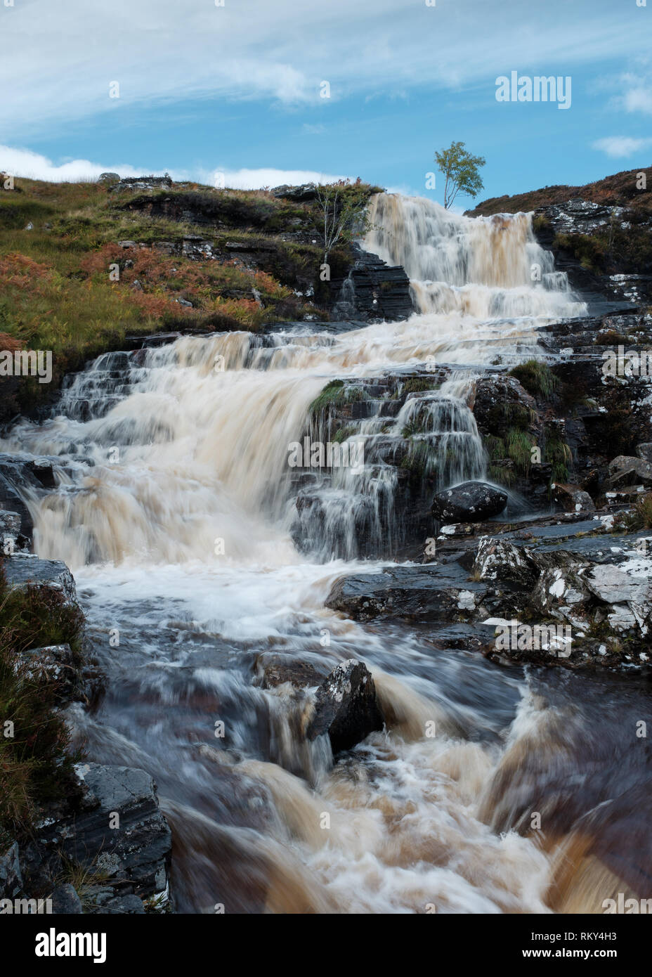 A beautiful Scottish waterfall cascading through rocks down a valley ...