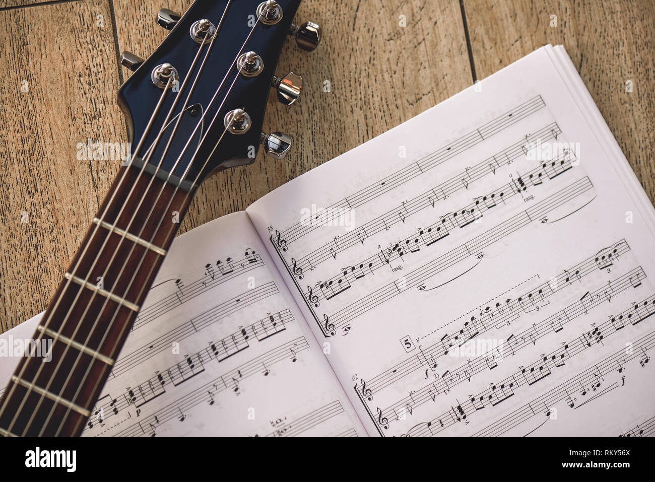 Playing guitar... Close-up photo of guitar neck and music notes against ...