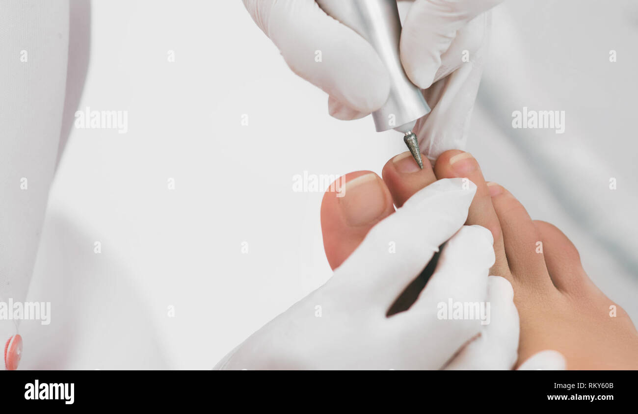 female legs close-up during a hardware manicure. Chiropodist service ...