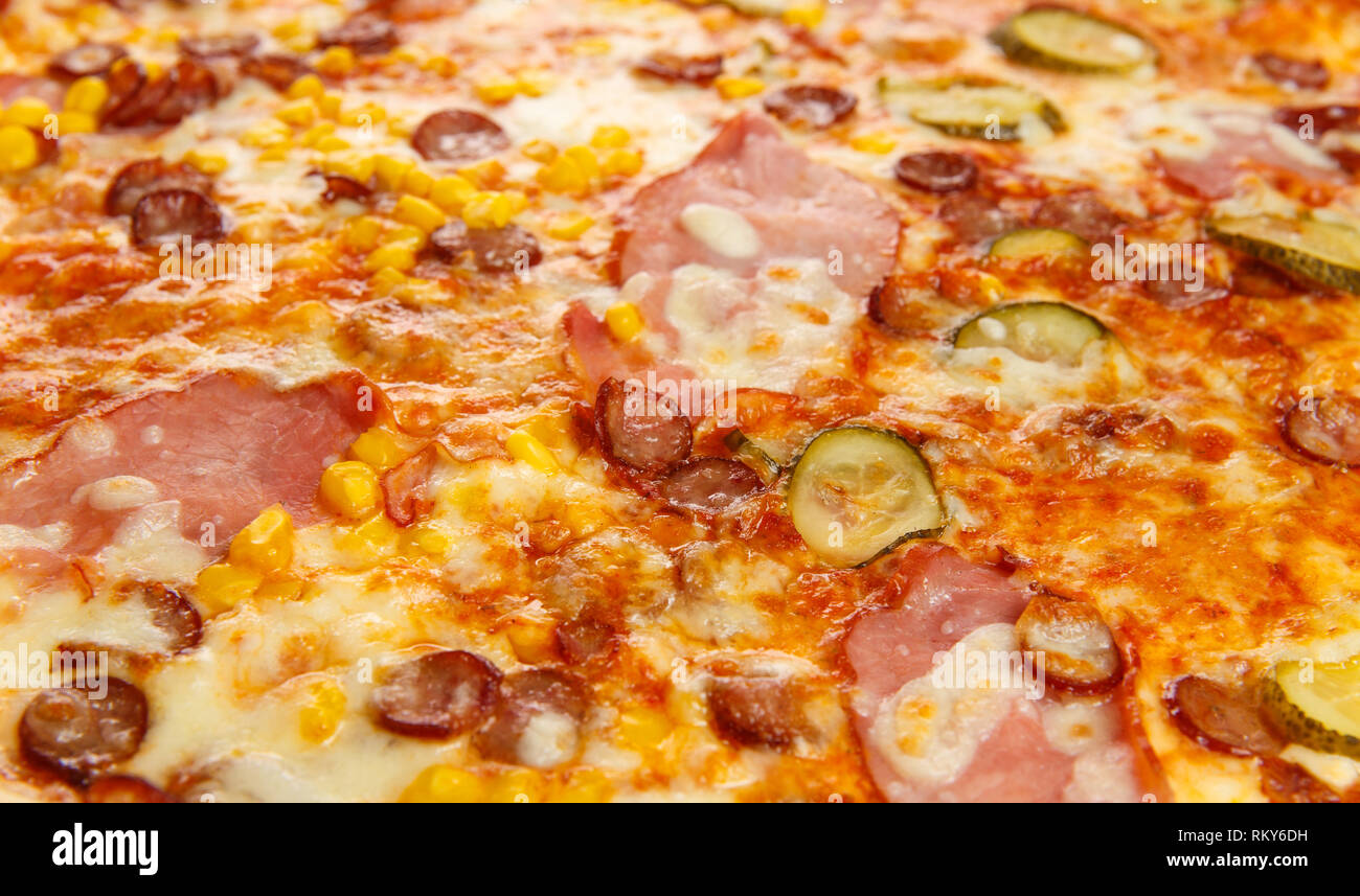 Background of delicious classic italian pizza with ham, sausages, corn ...