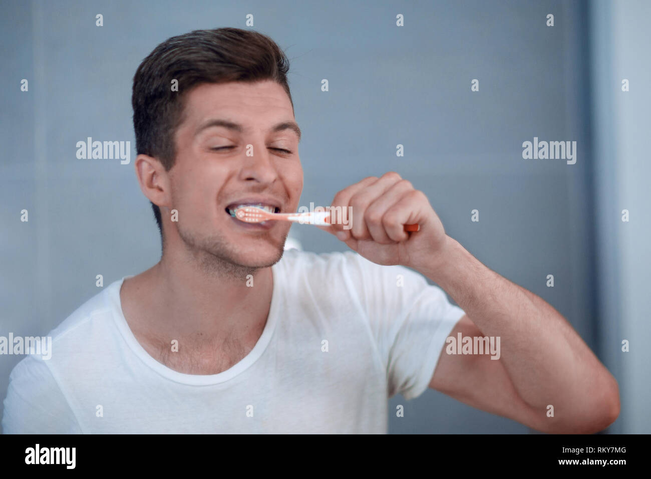 young man brushing his teeth in the bathroom Stock Photo - Alamy