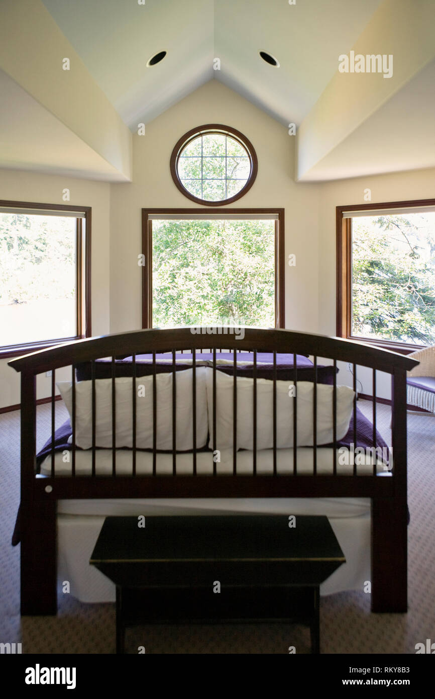 Bed facing bay windows in bedroom Stock Photo - Alamy