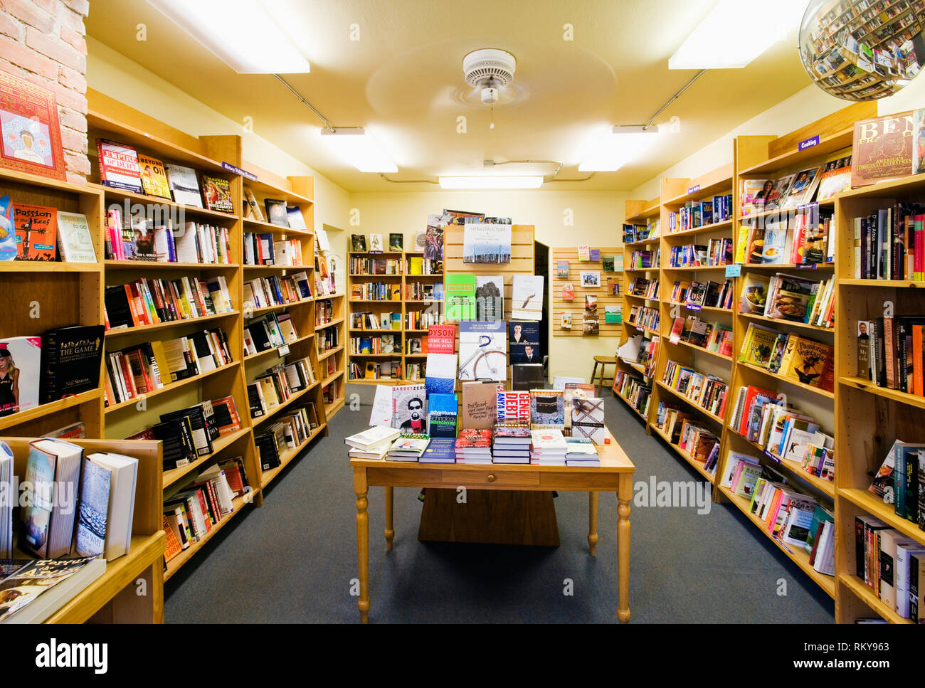 Books on shelves and table in bookstore Stock Photo - Alamy