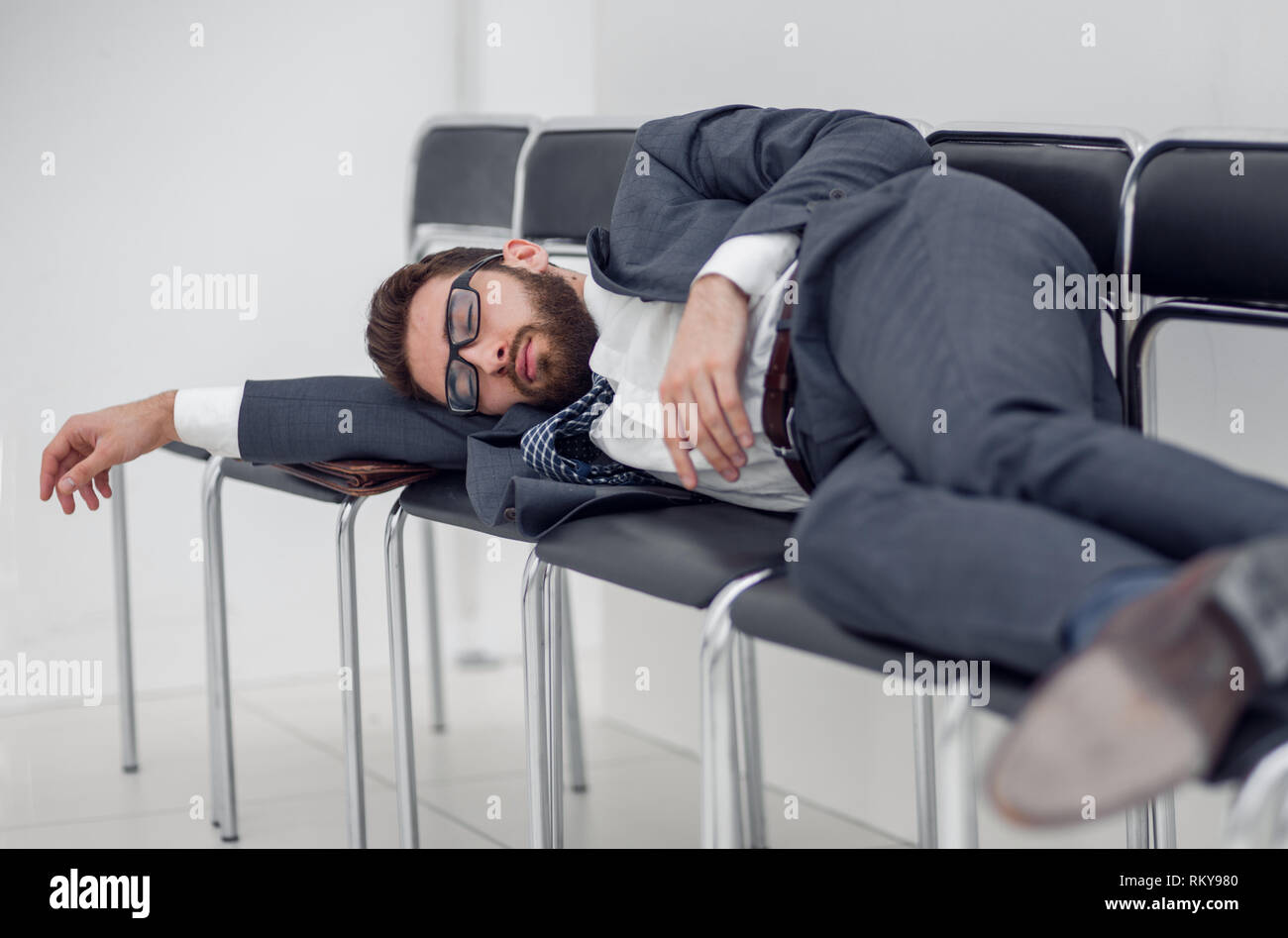 tired businessman lying on chairs and waiting for an interview Stock ...