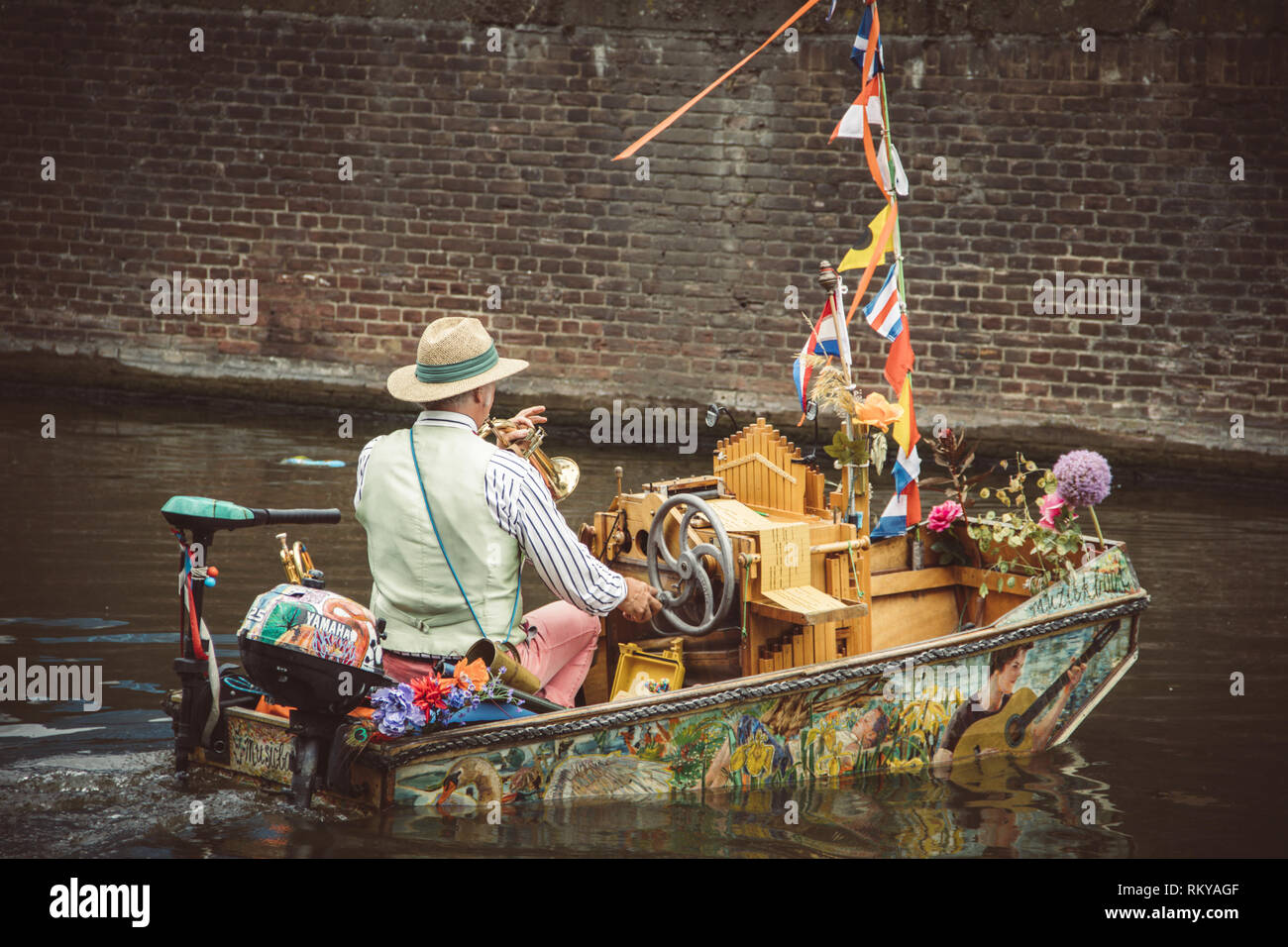 Man in colorful painted boat plays the trumpet Stock Photo - Alamy