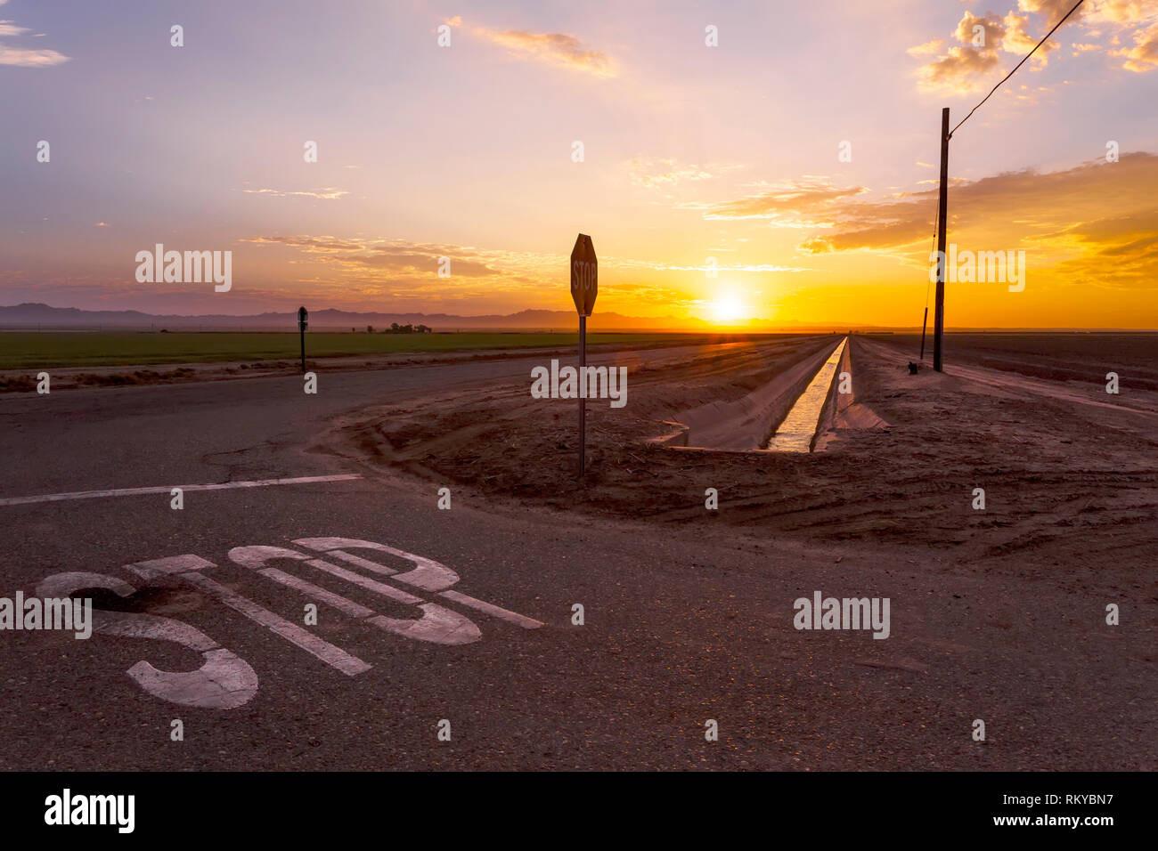 Stop sign at intersection of small country road through farmland in ...