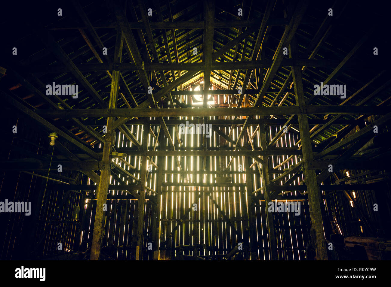 Sunlight shines through wooden slats of an old barn in Lawrenceburg in ...