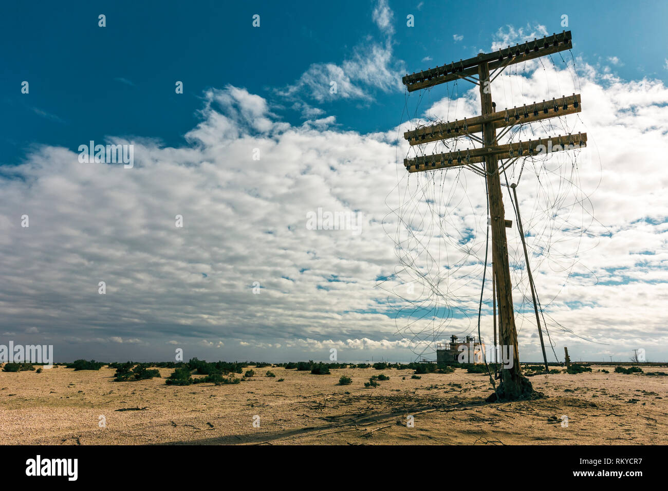 Abandoned powerline pole with disconnected and tangled wires in a ...