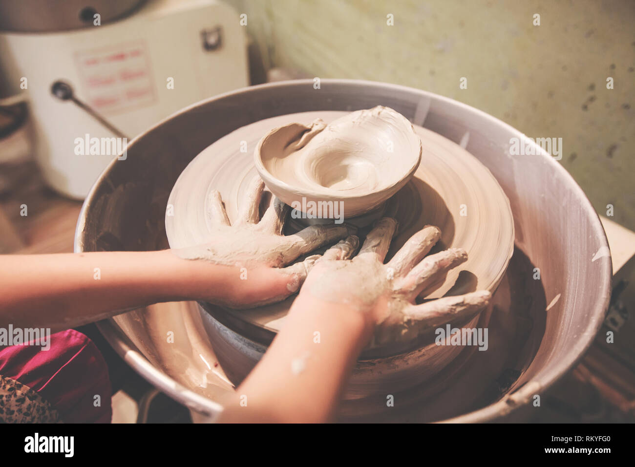 Child hands shaping clay on pottery wheel at workshop Stock Photo - Alamy