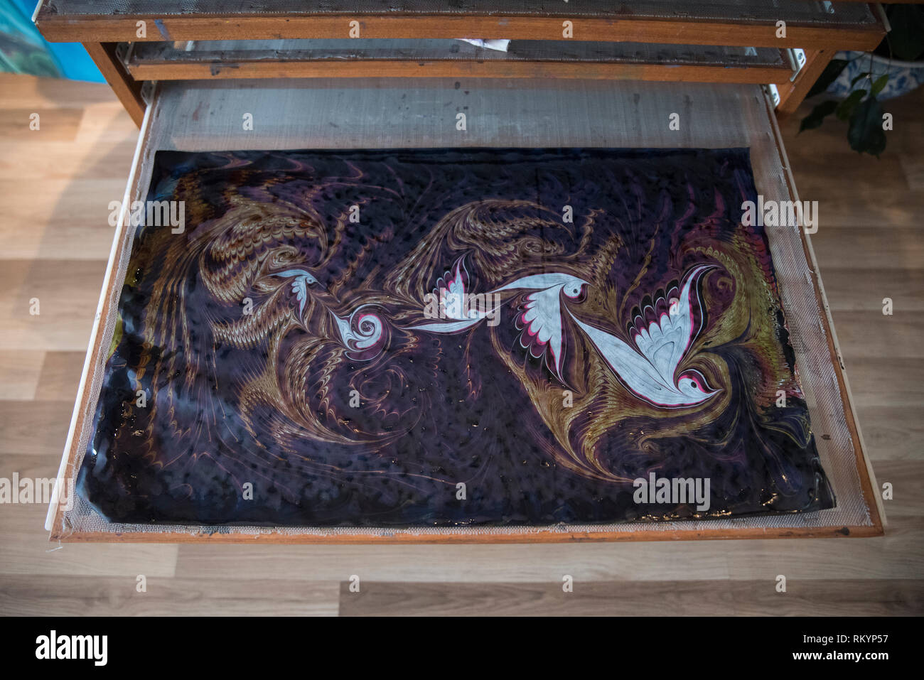 The finished Ebru design on paper is left to dry, then it is manually ...