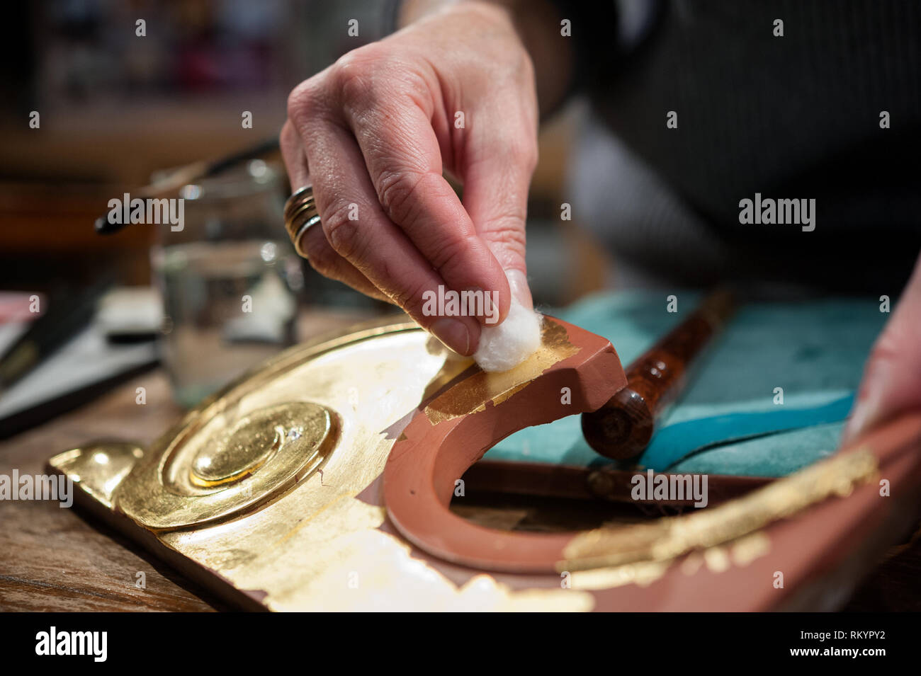 Craftsman uses a cotton pad during the gilding process tecnique Stock ...
