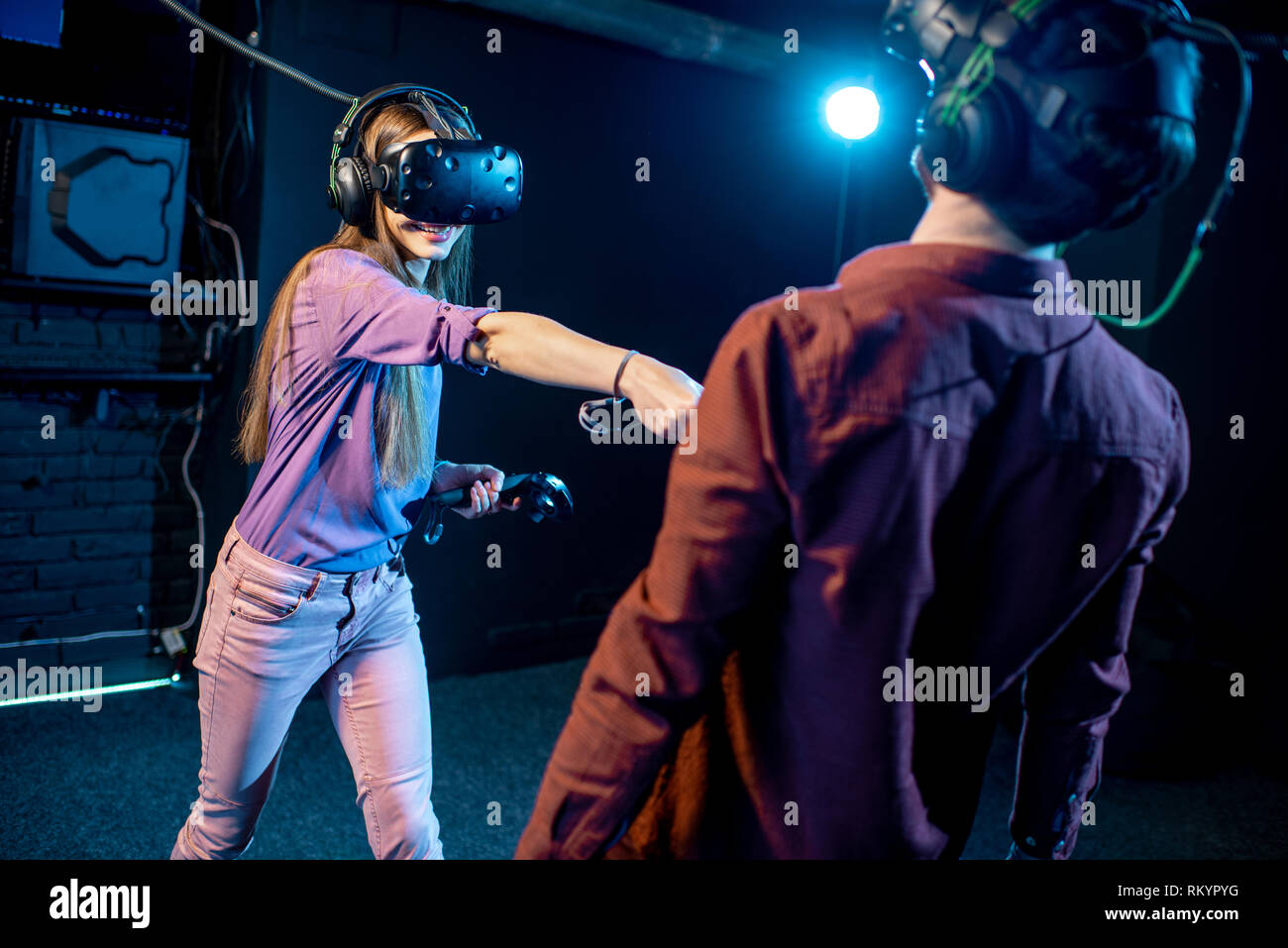 Man and woman playing game using virtual reality headset and gamepads ...