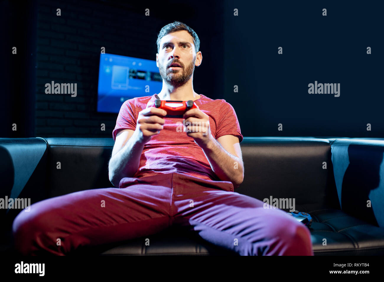 Man playing video games with gaming console and joy stick sitting on ...