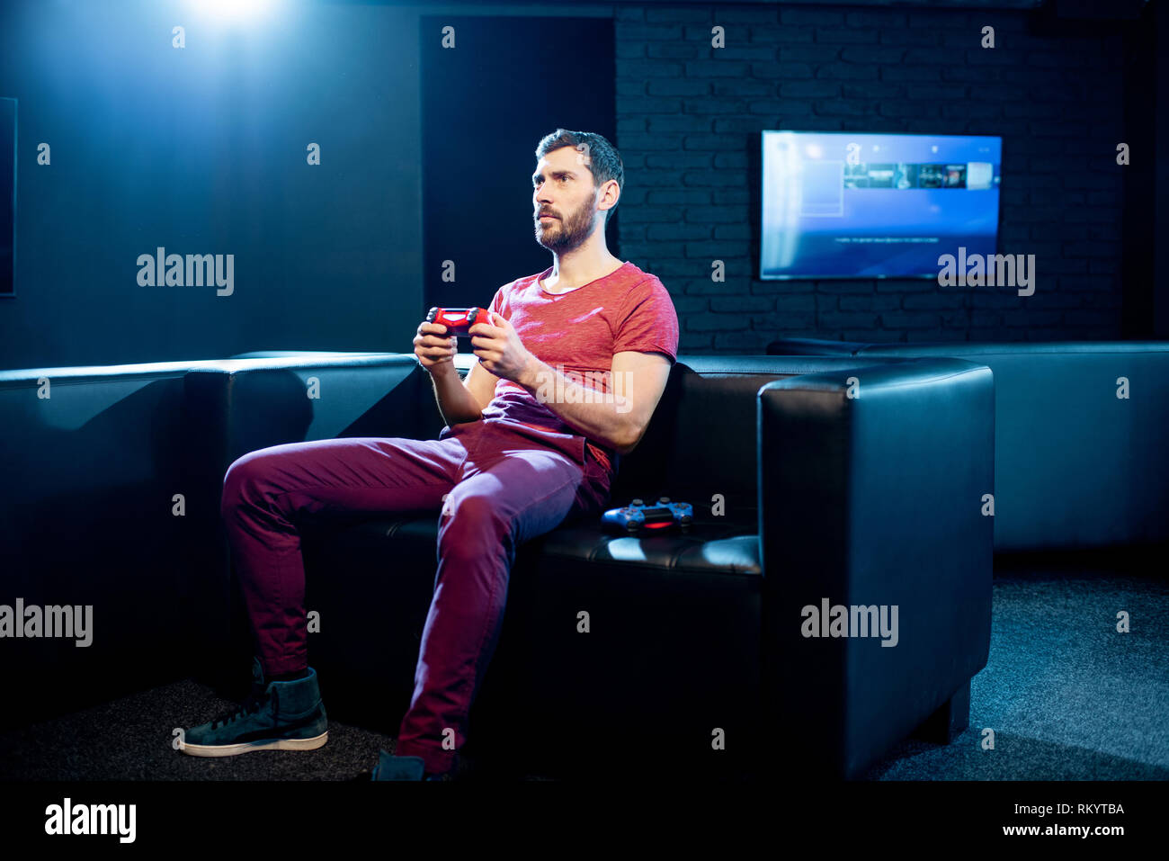 Man playing video games with gaming console and joy stick sitting on ...