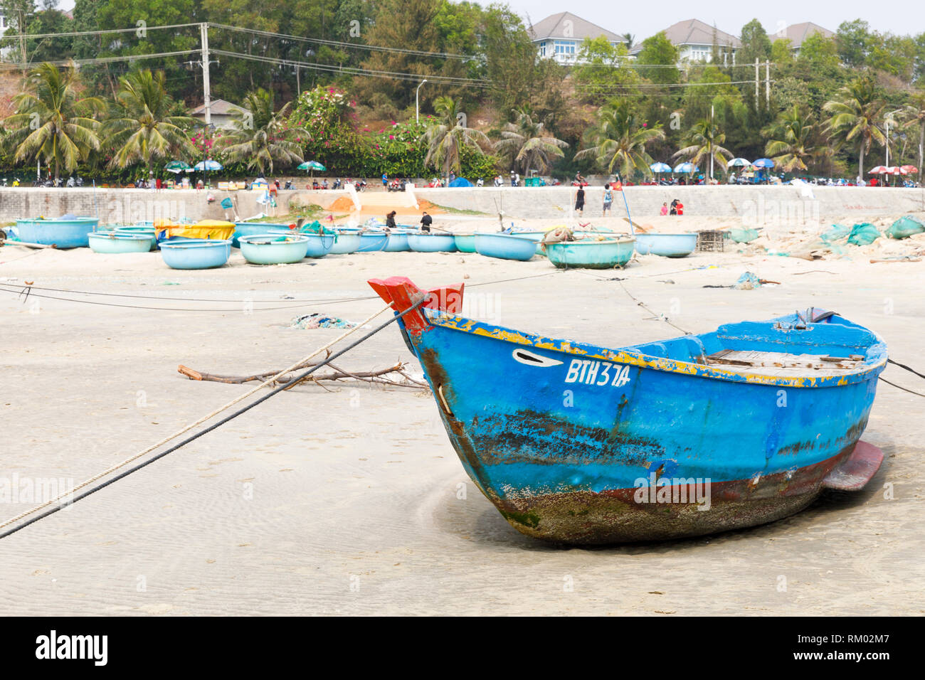 Blue fishing boat on sandy ground near water front in Vietnam Stock ...