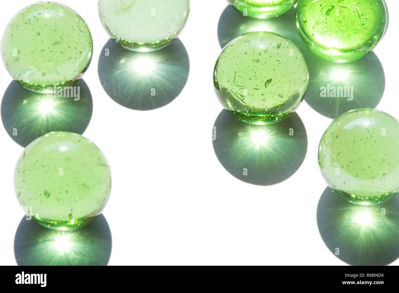 Green glass marbles with shadows Stock Photo - Alamy