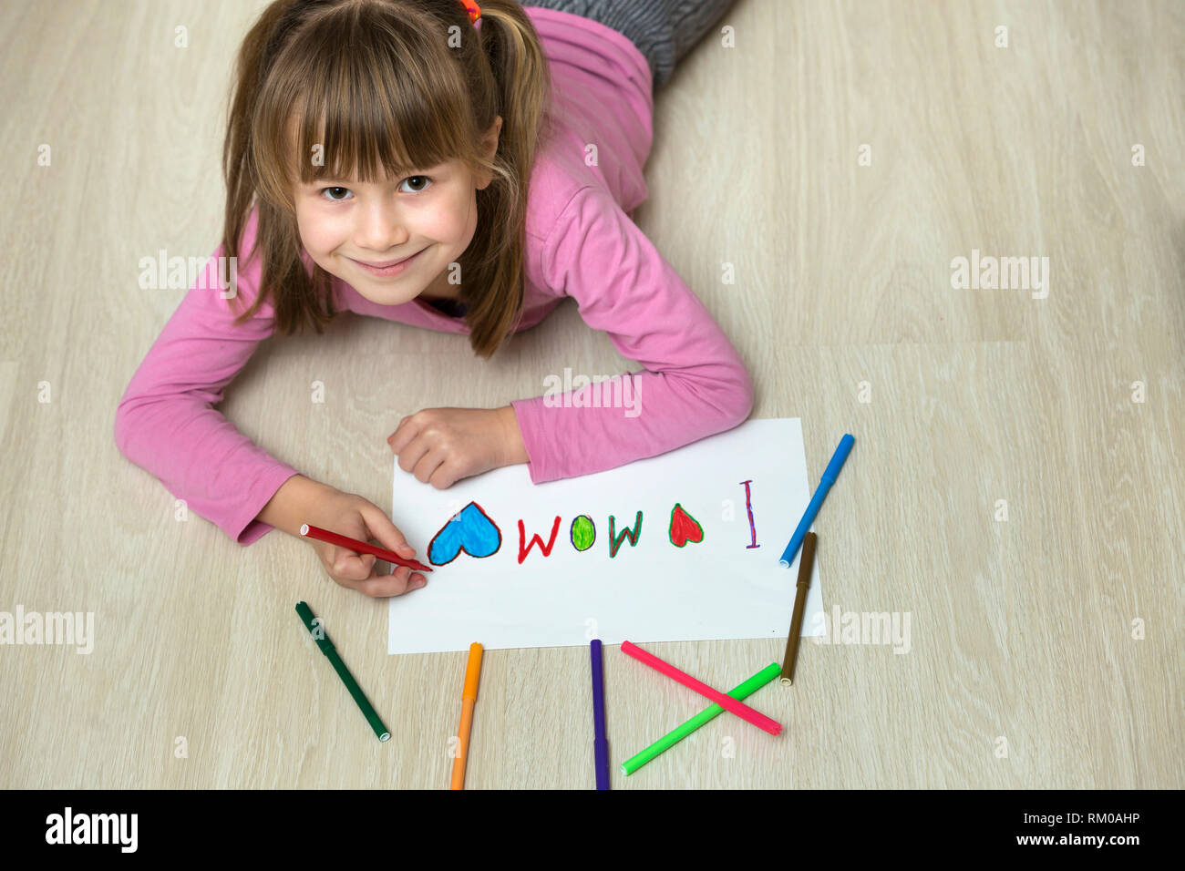 View from above of cute child girl drawing with colorful crayons I love ...