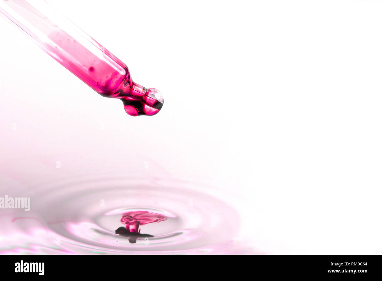 pink ink dripping on a water surface with small waves Stock Photo - Alamy