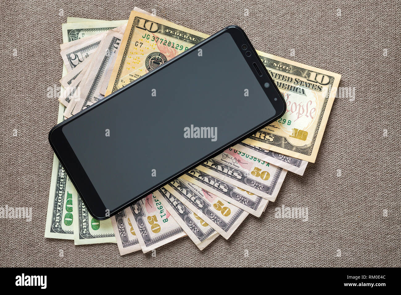 New black modern cellphone on money dollars banknotes background ...