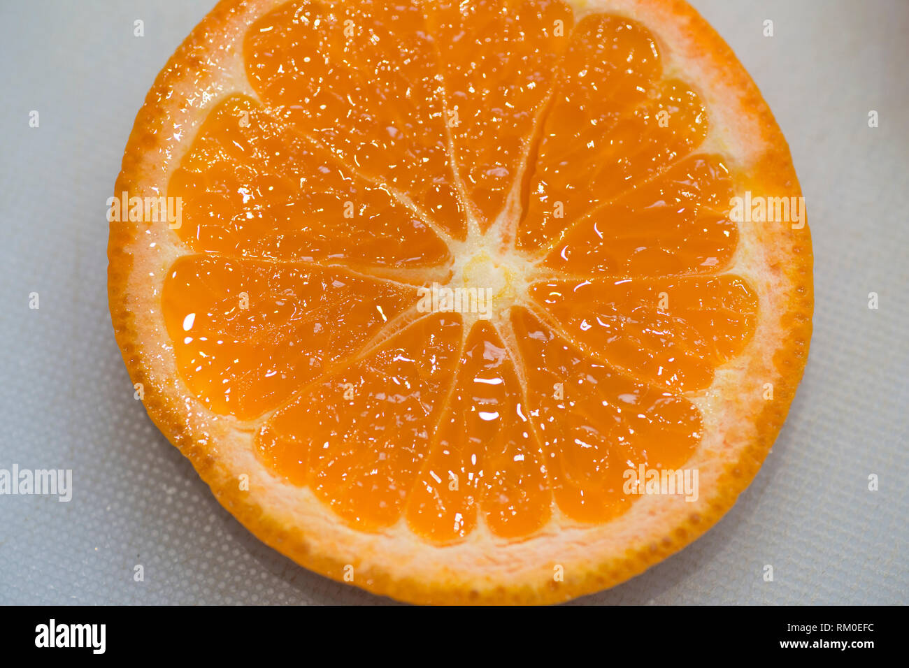 Freshly sliced oranges on a chopping board, showing the juicy fruit ...