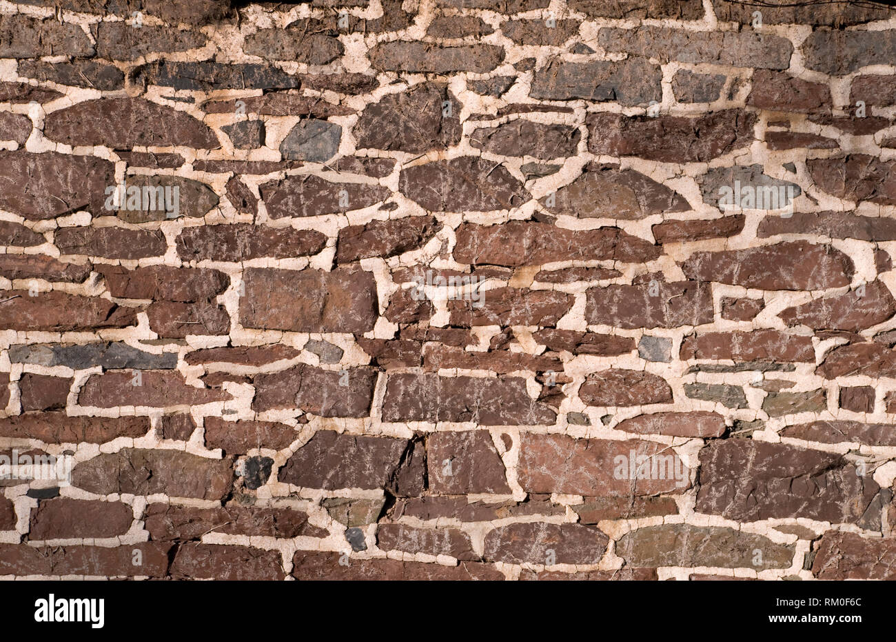 Old masonry wall using irregular red-brown stones Stock Photo - Alamy