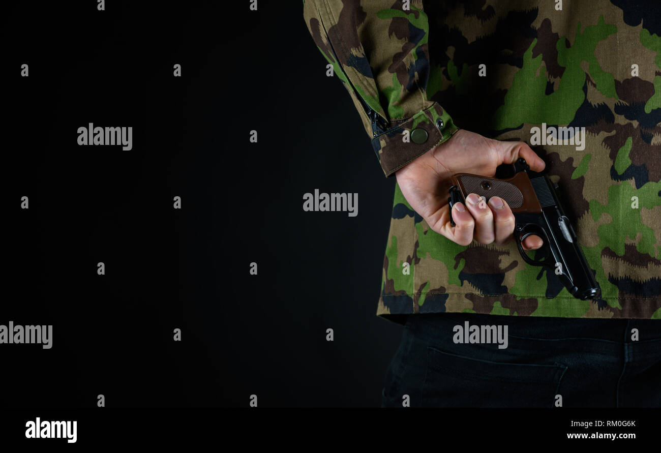 Soldier holds his gun behind his back Stock Photo - Alamy