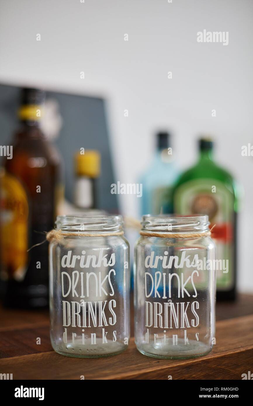 Still life of two glass jars with liquor bottles in background Stock ...
