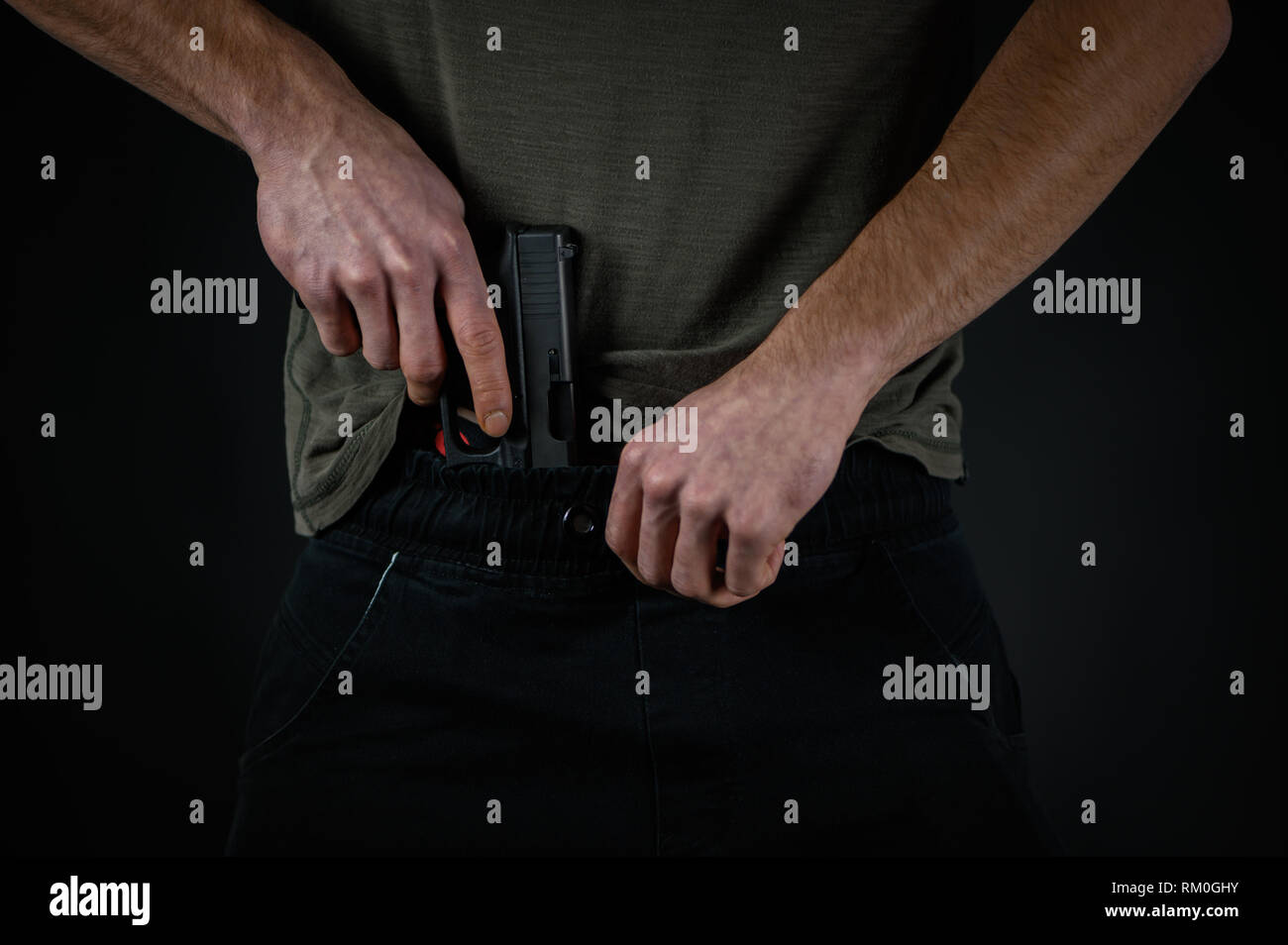 Man try to hide his pistol under his pants Stock Photo - Alamy