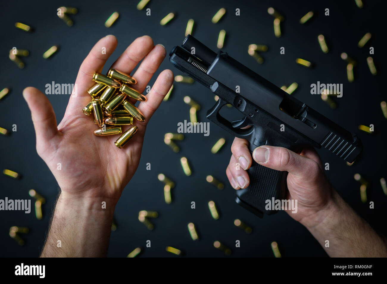 Gun and ammunition in the hands ready to load Stock Photo - Alamy