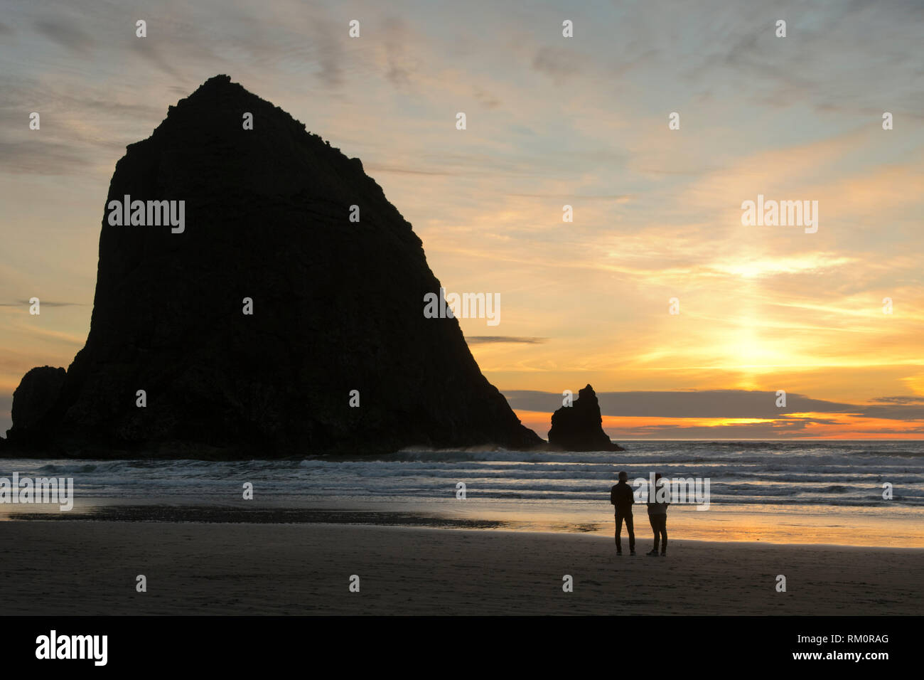 Couple walking at sunset, Cannon Beach, Oregon Stock Photo - Alamy