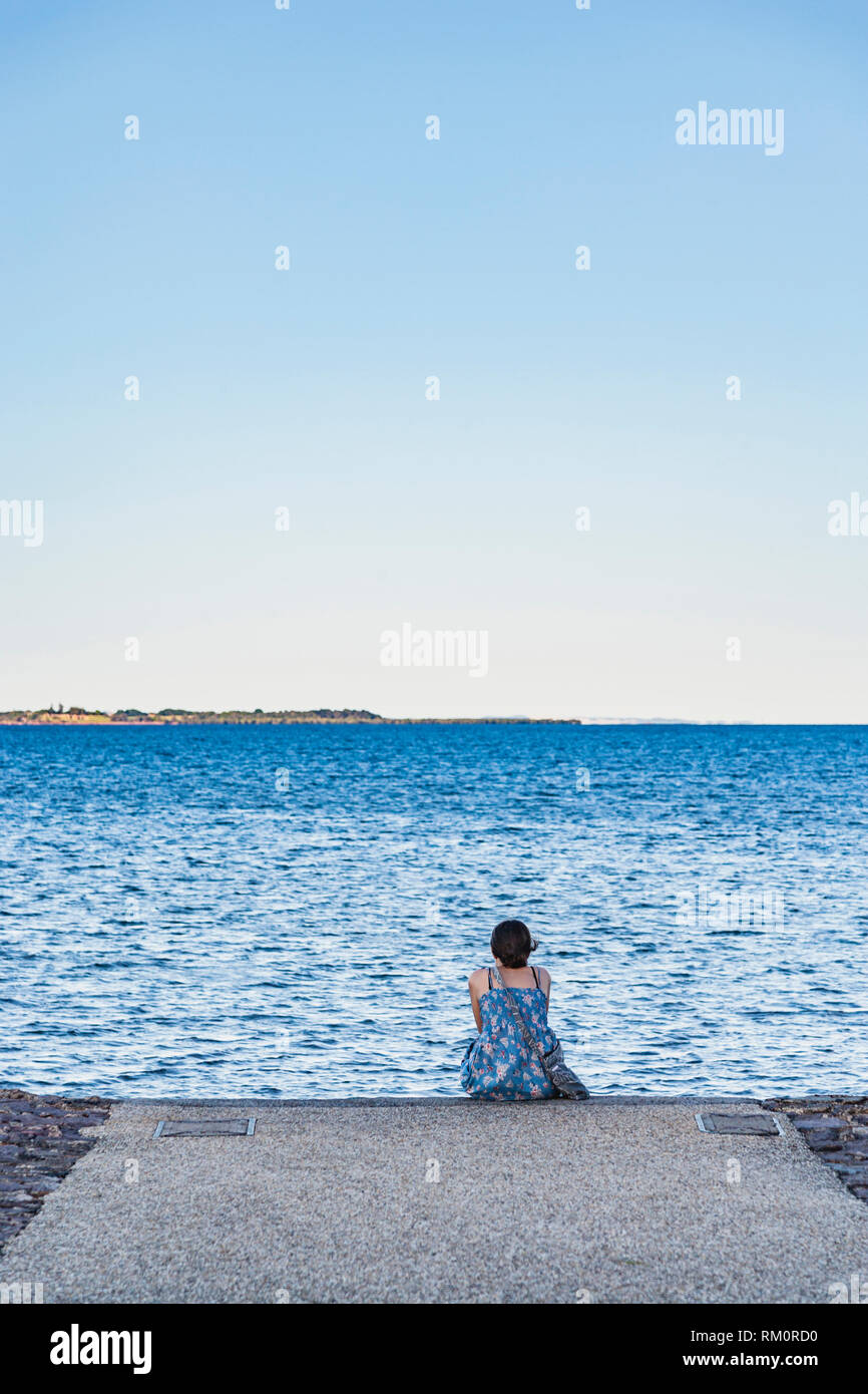 A person enjoying sunset looking out to sea Stock Photo - Alamy