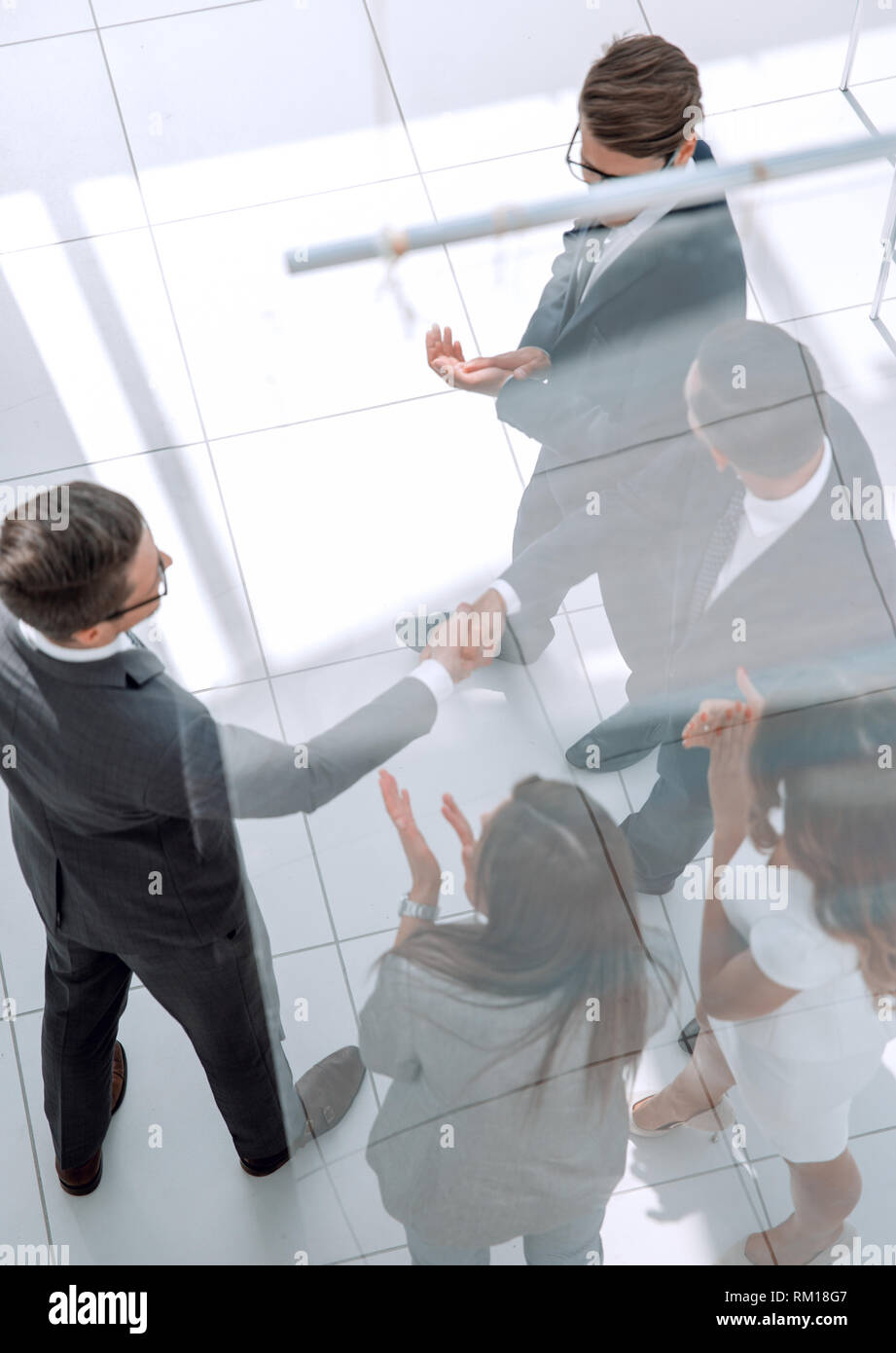 handshake business partners behind the glass door Stock Photo - Alamy