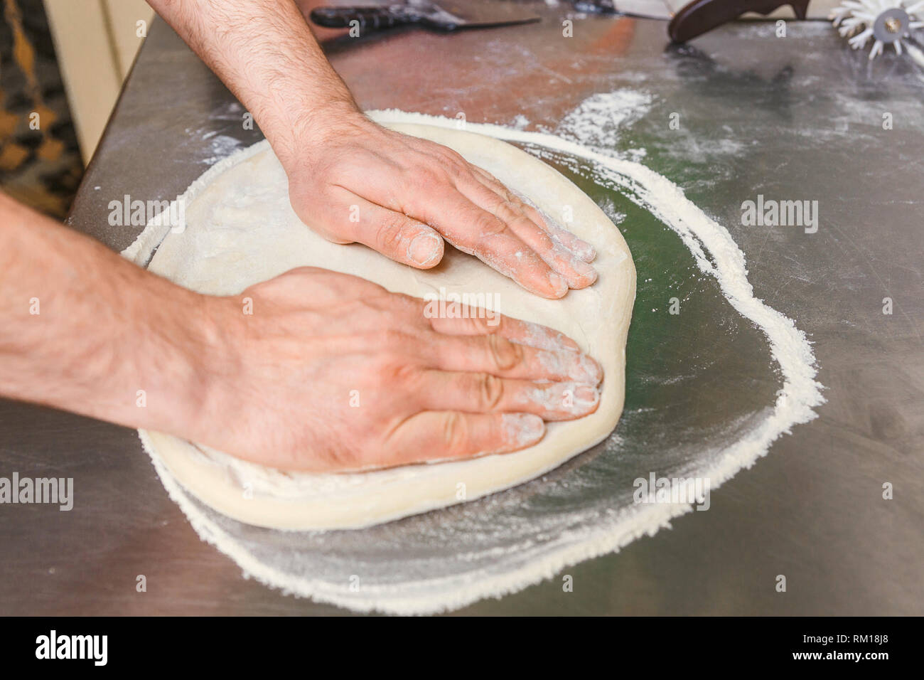 Cook forms a dough pizza base. Hands closeup Stock Photo - Alamy