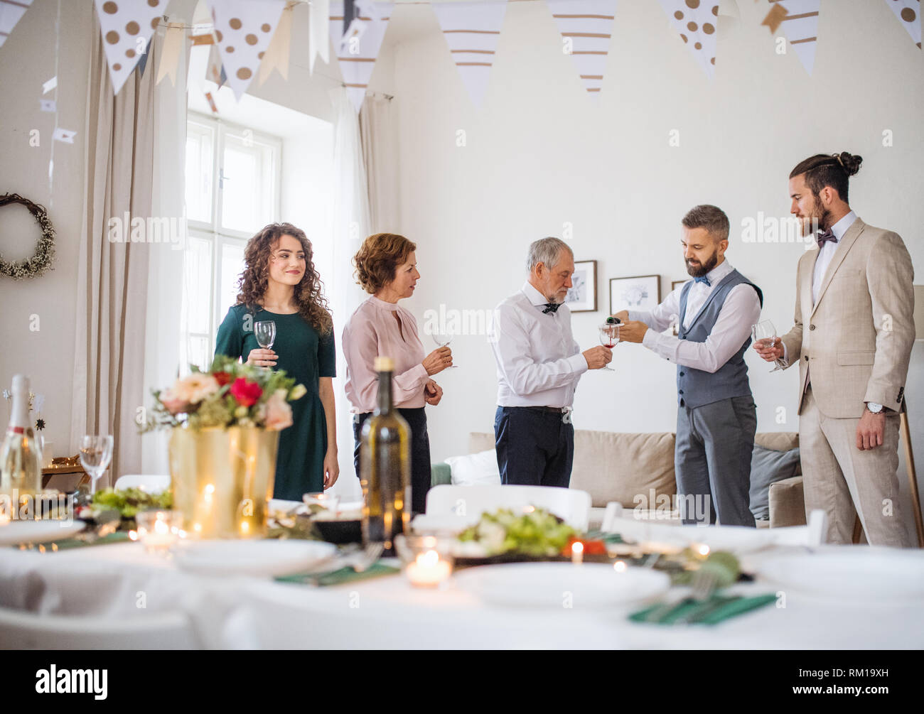 A man pouring guests wine on a indoor family birthday party Stock Photo ...