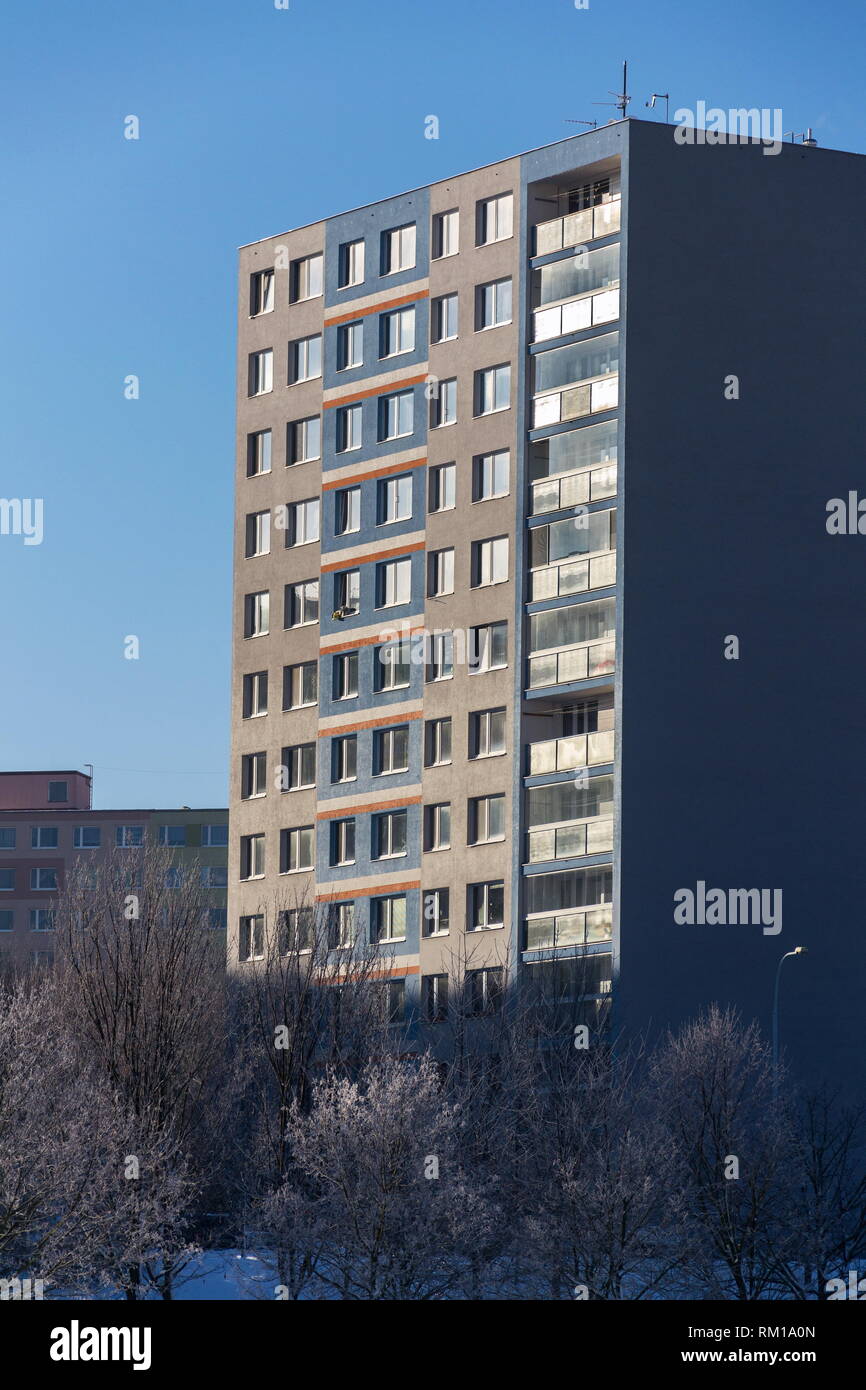 Insulated panel house apartments behind trees, high-rise block of flats ...