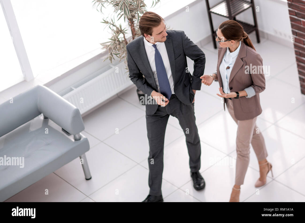 Manager talking to an employee in the office lobby Stock Photo - Alamy