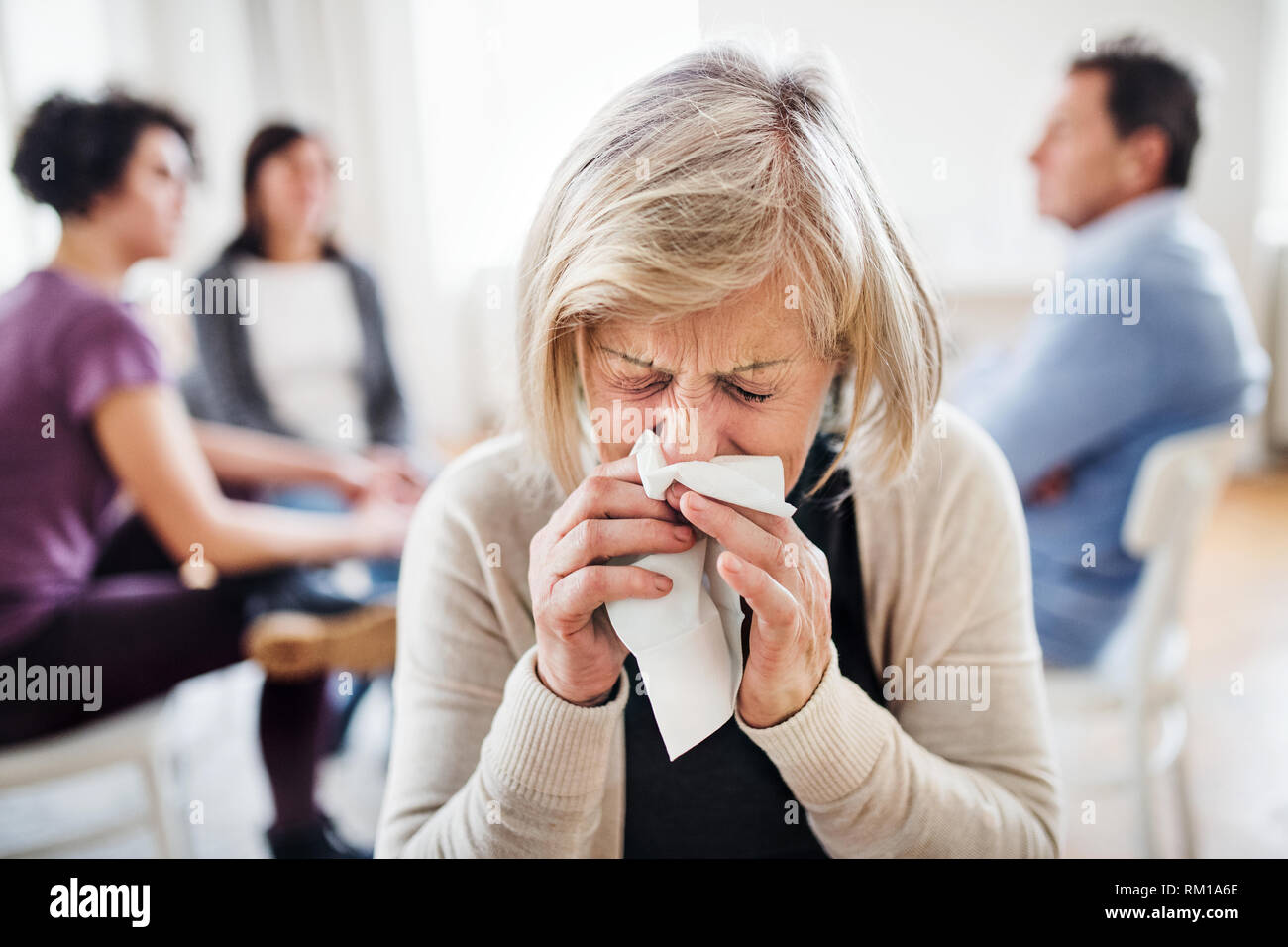 A portrait of senior depressed woman crying during group therapy Stock ...