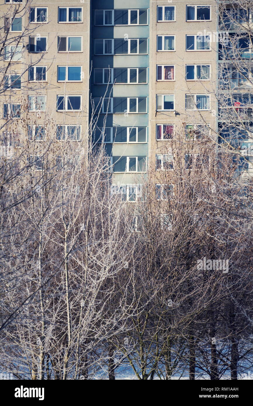 Insulated panel house apartments behind trees, high-rise block of flats ...