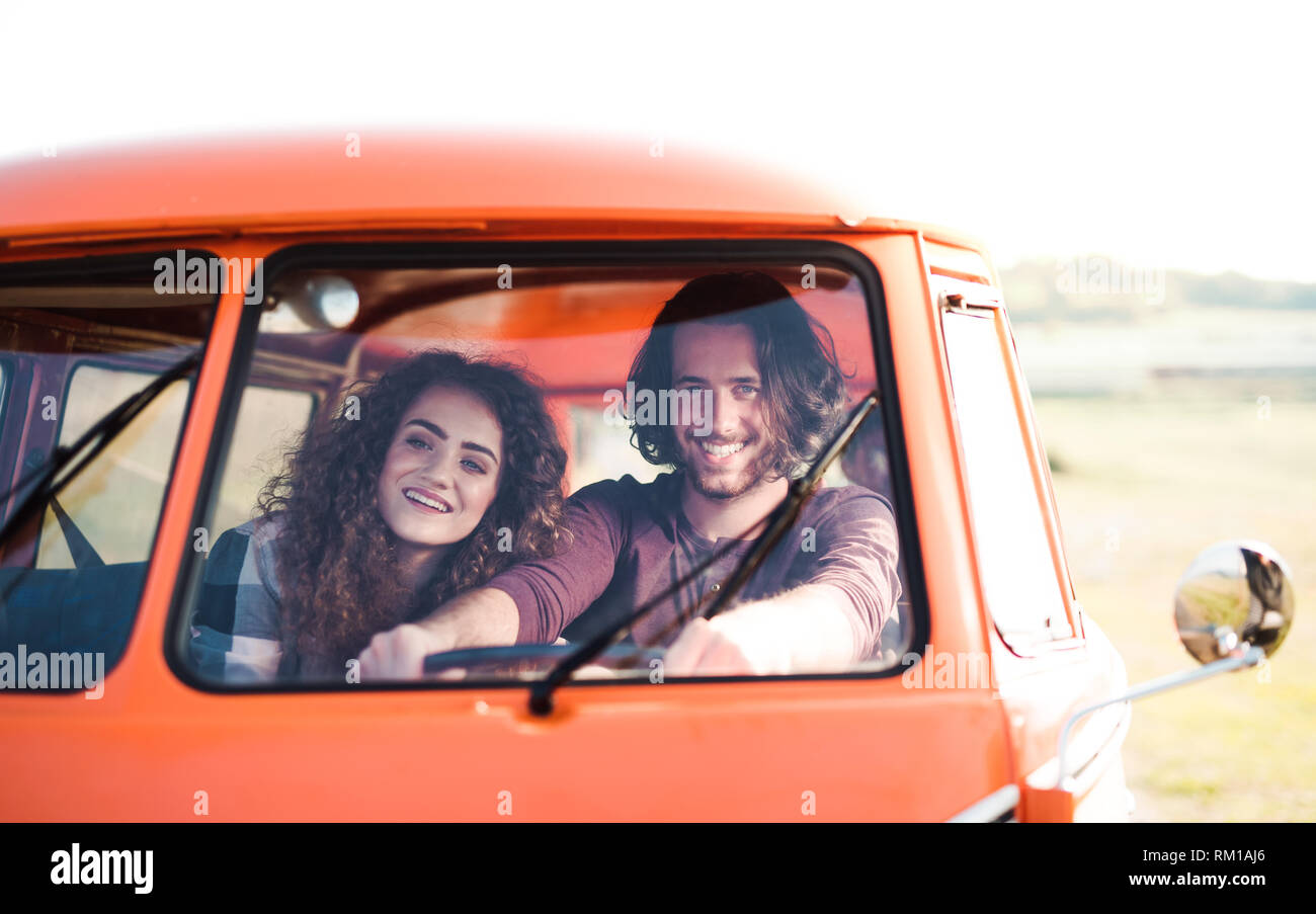 A young couple on a roadtrip through countryside, driving minivan Stock ...