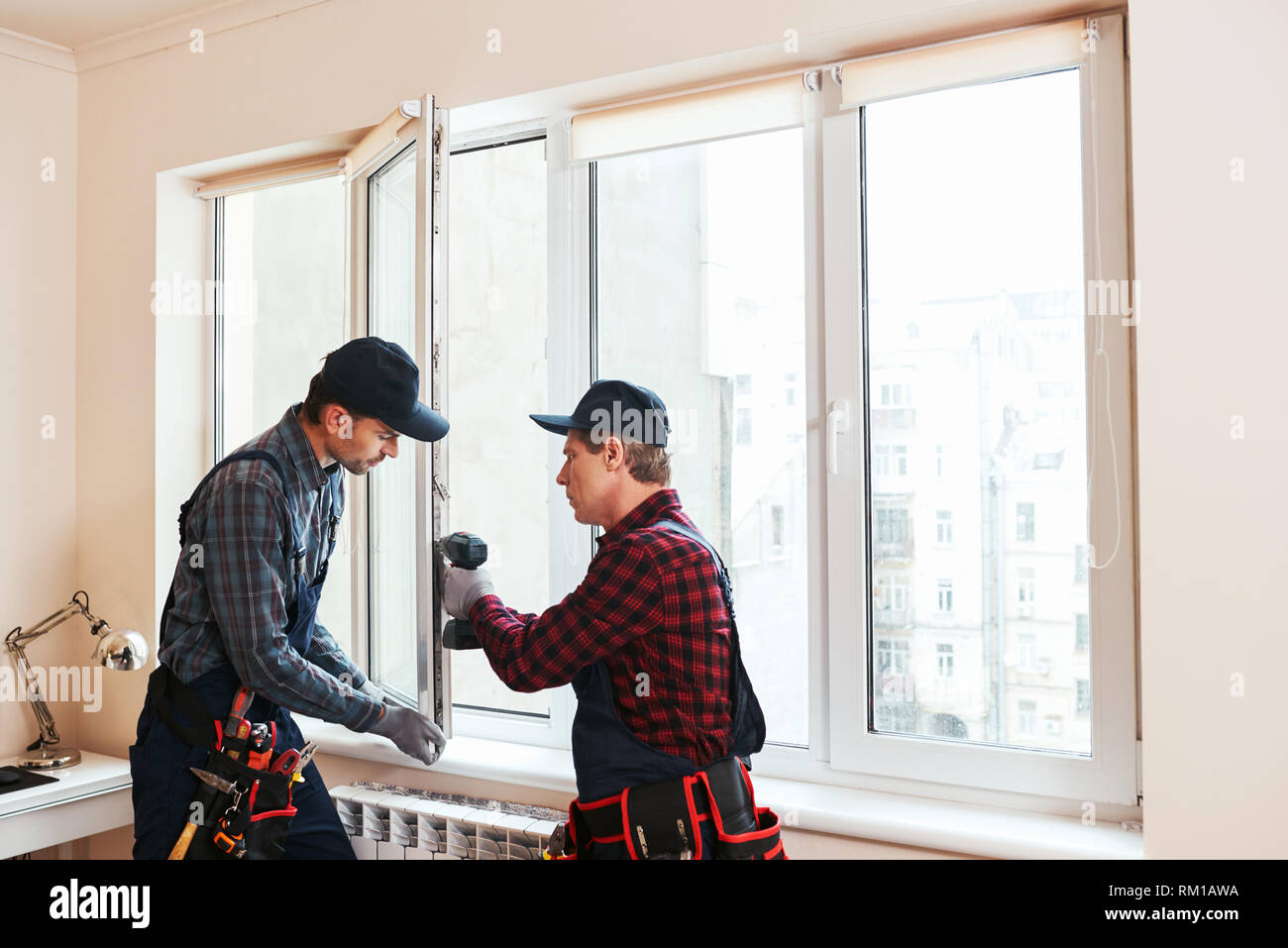 Quality light. Construction workers installing new window in house ...