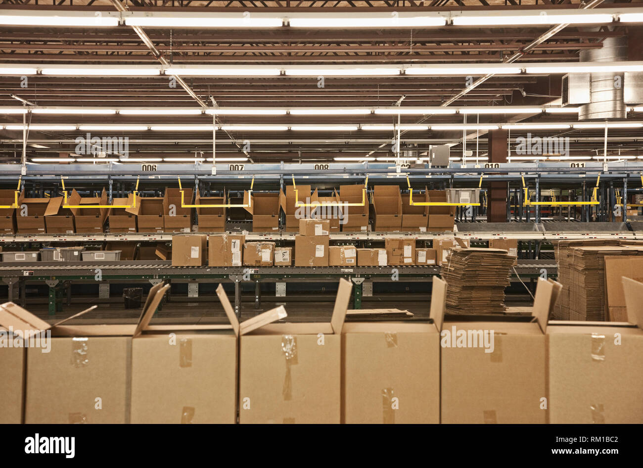 Cardboard boxes along production line in warehouse Stock Photo - Alamy