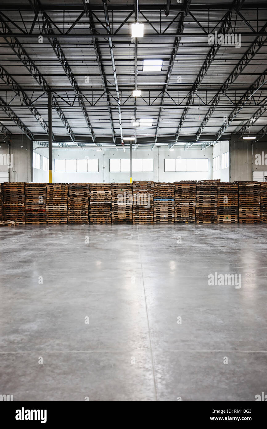 Pallets stacked in warehouse Stock Photo - Alamy