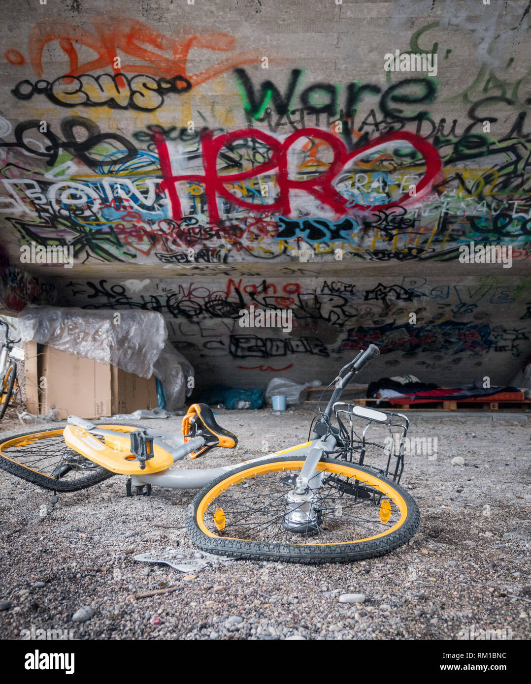 Old yellow scrap bicycles under concrete stairs with graffiti and ...